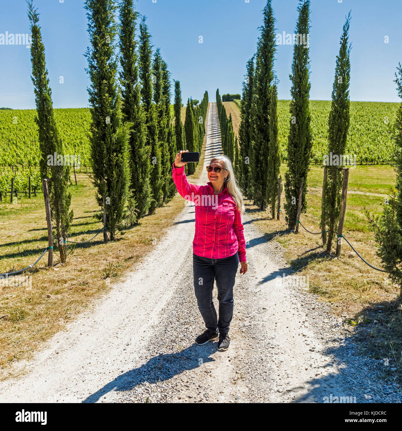 Caucasian woman posing for cell phone selfie on dirt road Stock Photo ...