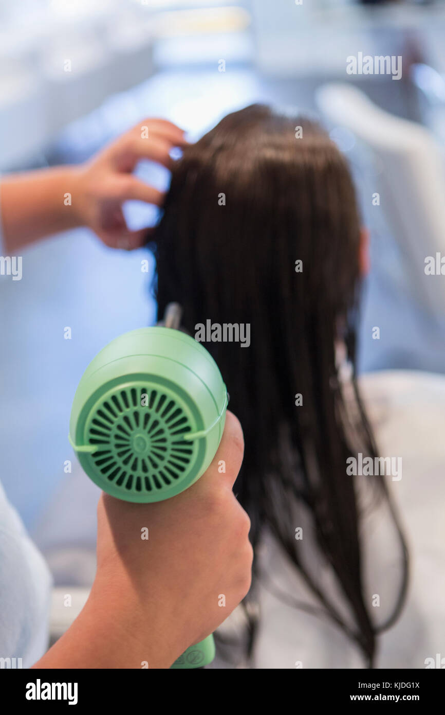 Caucasian stylist drying hair of woman Stock Photo - Alamy