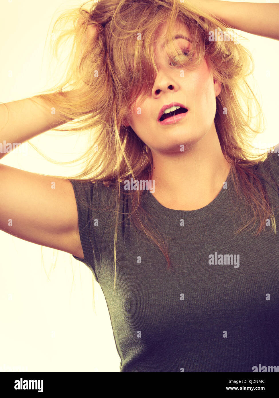 Bad hairstyle concept. Crazy, mad blonde woman with messy hair looking ...
