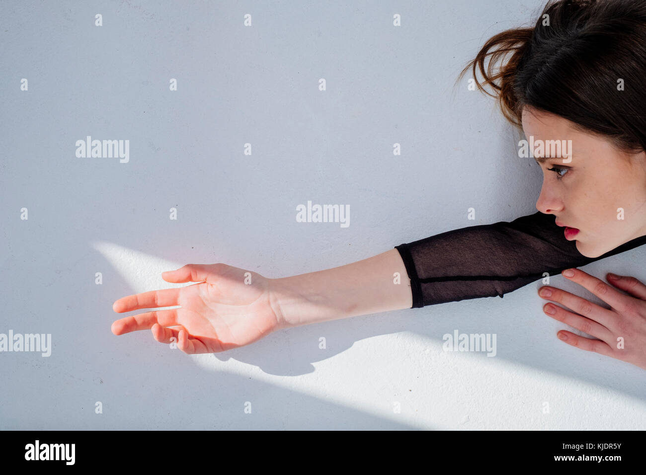 Serious Caucasian woman reaching for light Stock Photo - Alamy