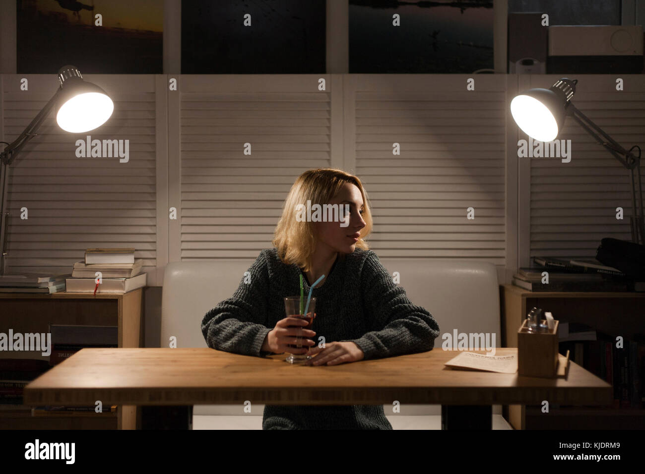 Caucasian woman sitting at desk drinking beverage Stock Photo - Alamy