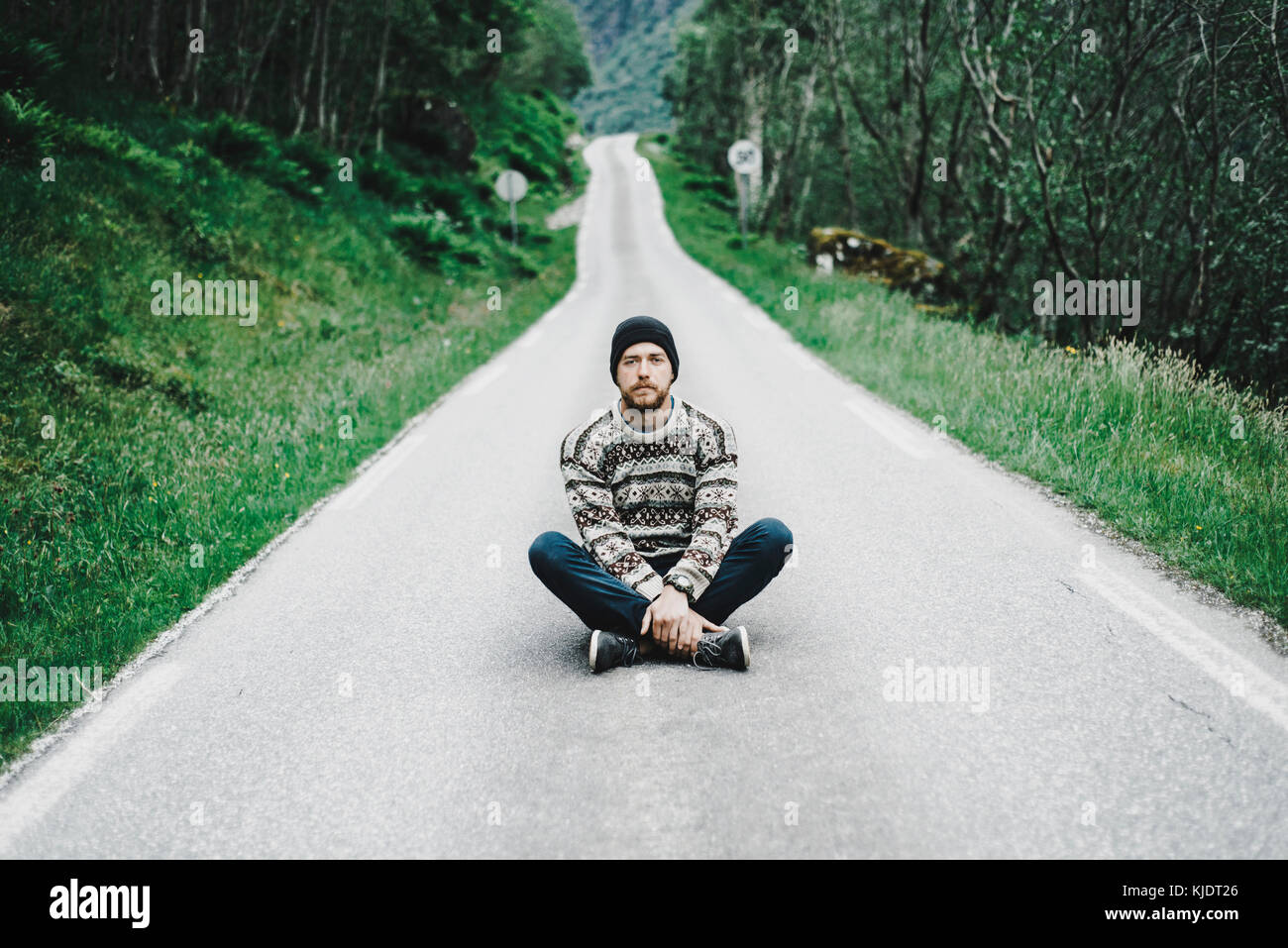 Caucasian man sitting in middle of road Stock Photo - Alamy