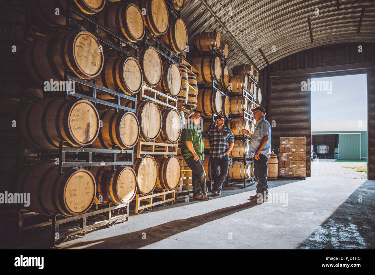 Caucasian men talking near barrels in distillery Stock Photo - Alamy
