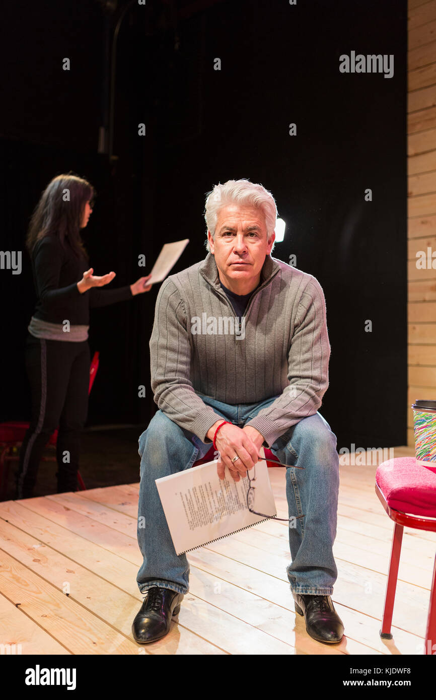 Hispanic man holding script on theater stage Stock Photo - Alamy