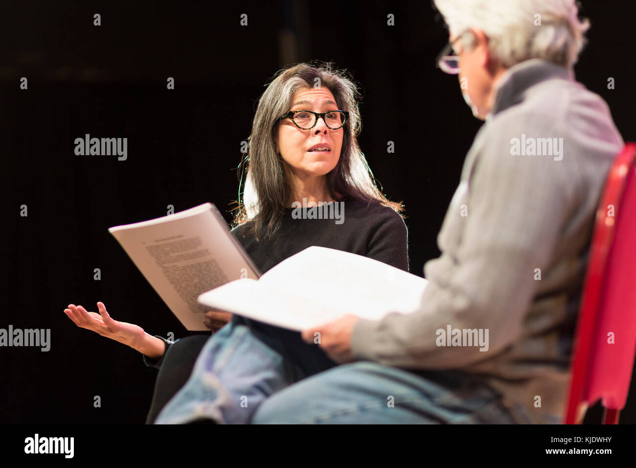 Hispanic man and woman reading scripts on theater stage Stock Photo - Alamy