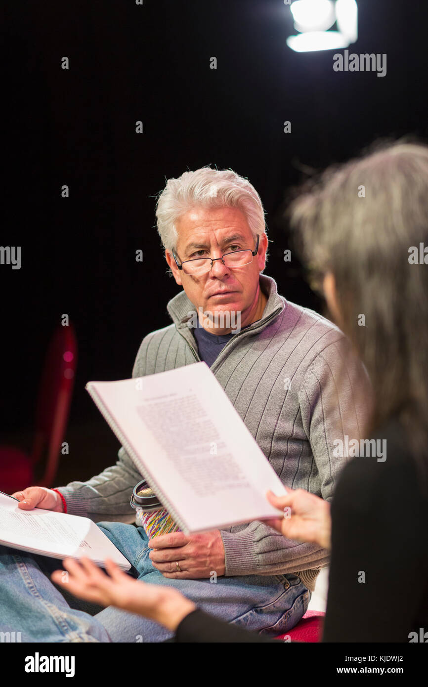 Hispanic man and woman reading scripts in theater Stock Photo - Alamy