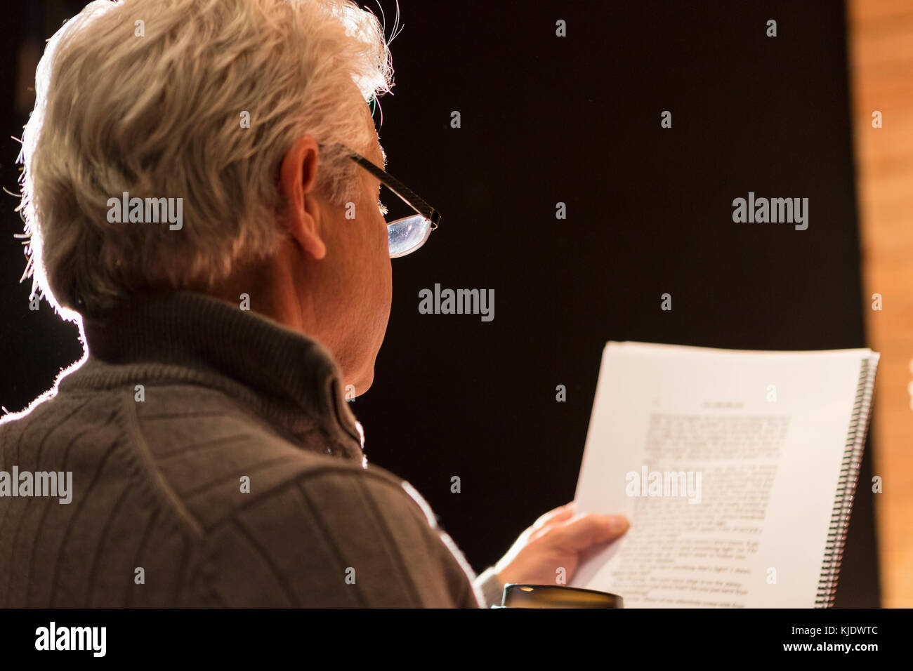 Hispanic man reading script in theater Stock Photo - Alamy