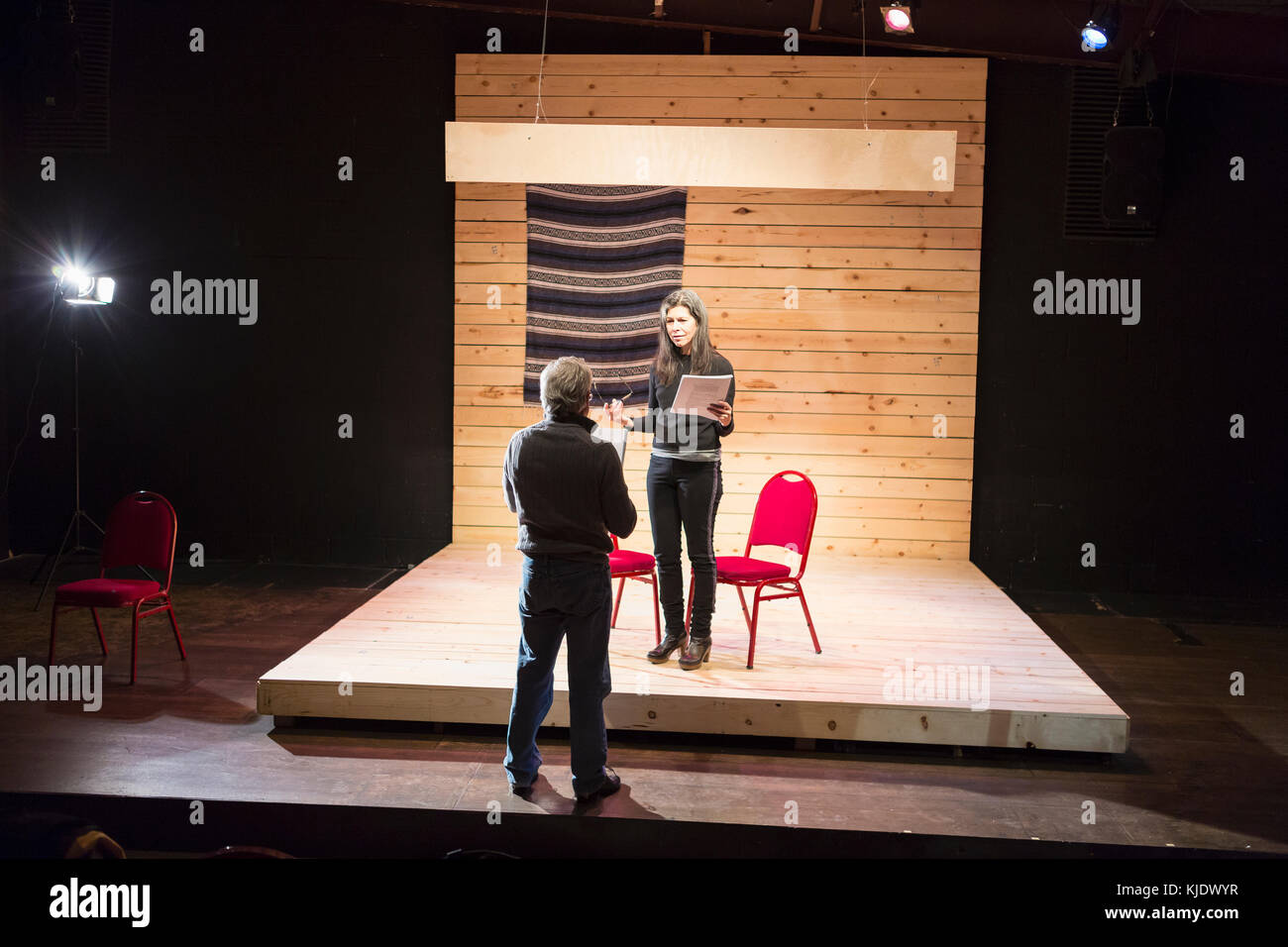 Hispanic man and woman reading scripts on theater stage Stock Photo - Alamy