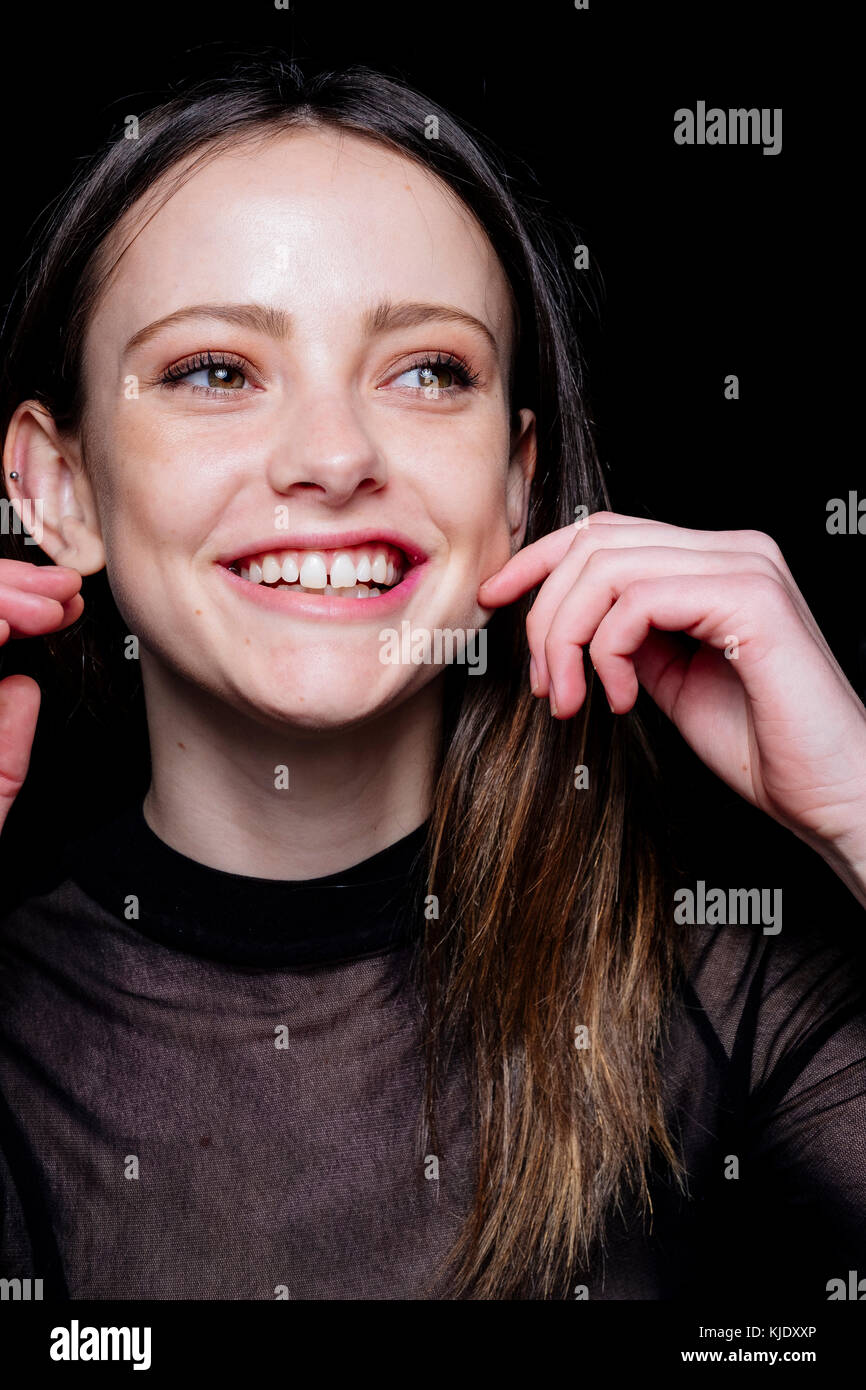 Smiling Caucasian woman pinching cheek Stock Photo - Alamy