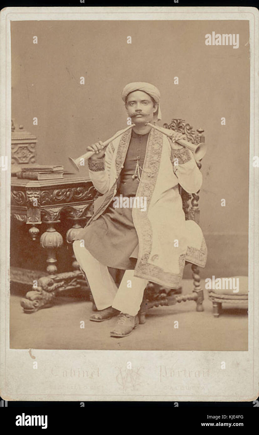 Bengal man in costume holding two horns to throat Stock Photo - Alamy