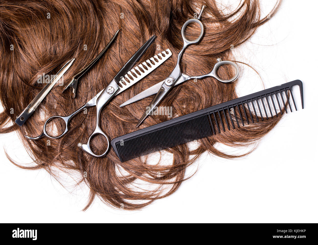 Long brown hair with scissors on close up isolated on white background ...