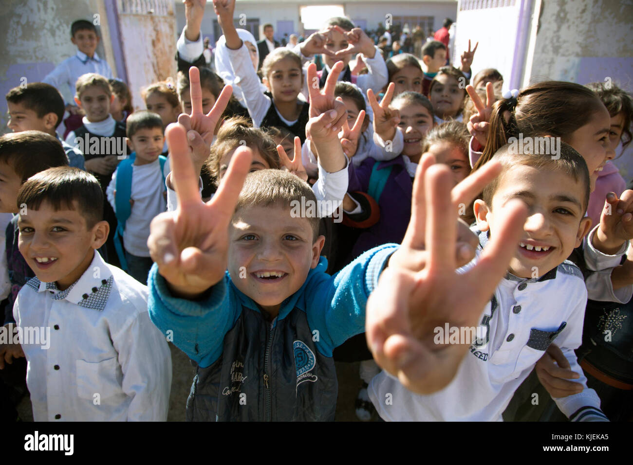 Iraqi students pose for a photo at a primary school in the Village of ...
