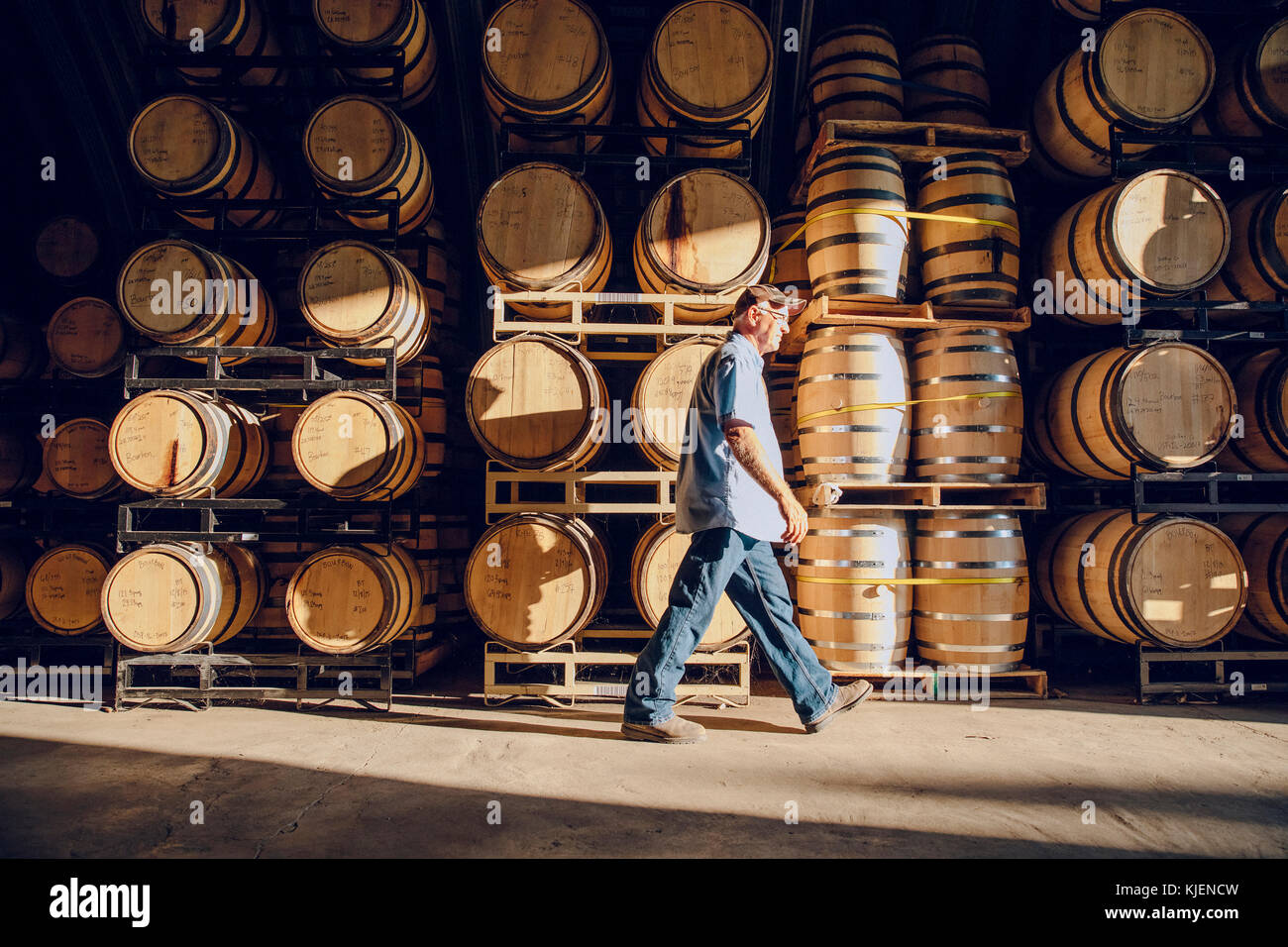 Caucasian man walking near barrels in distillery Stock Photo - Alamy