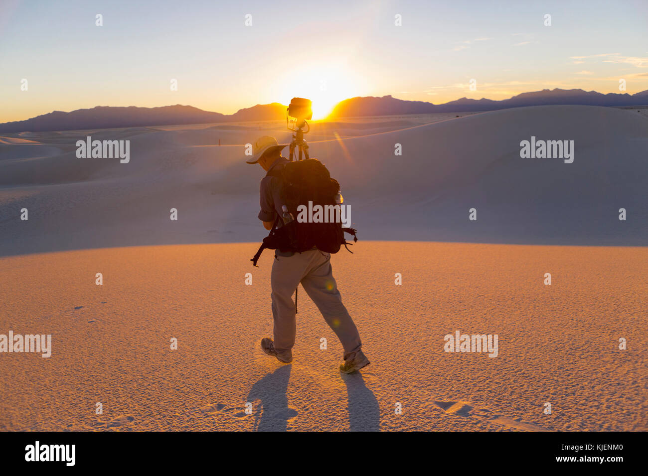Caucasian man carrying camera and tripod in desert Stock Photo - Alamy