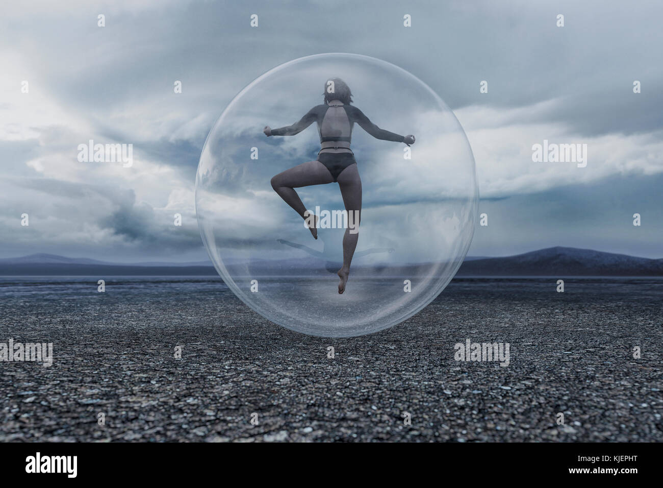 Woman floating in sphere in remote landscape Stock Photo - Alamy