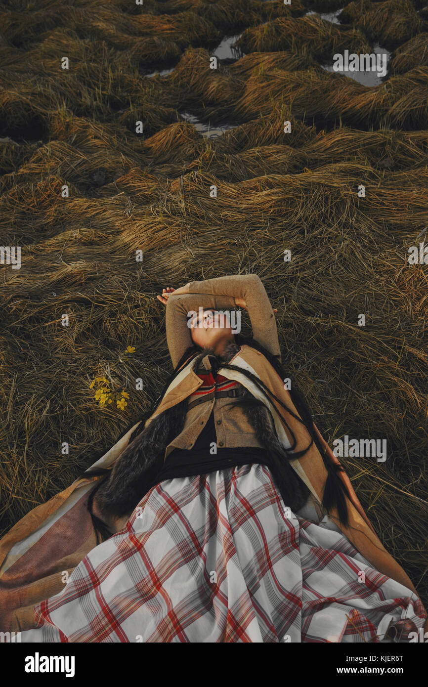 Caucasian woman wearing traditional clothing laying in grass Stock ...