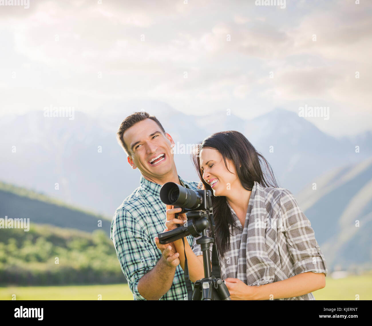 Couple with camera laughing Stock Photo - Alamy