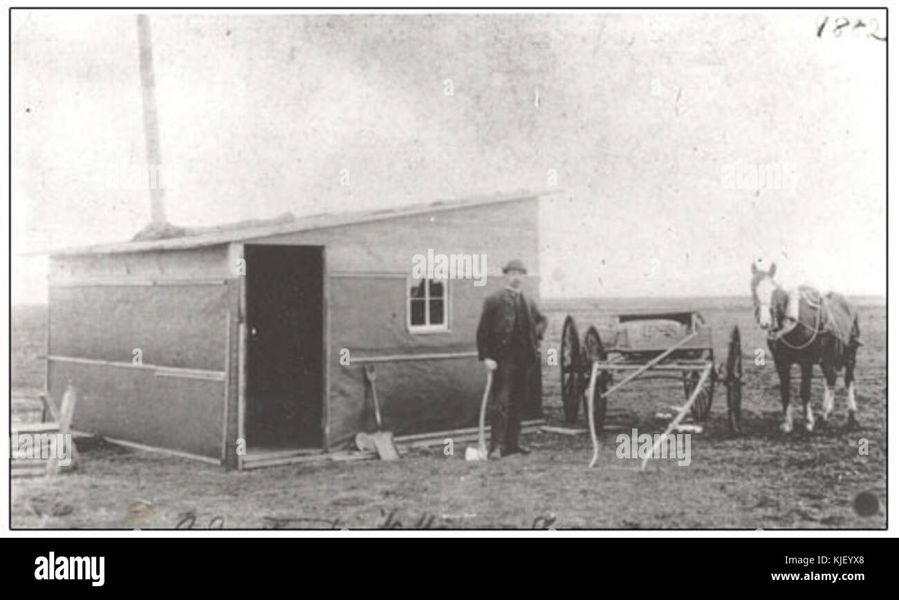 Unidentified man with horse and cart beside the first house built in ...