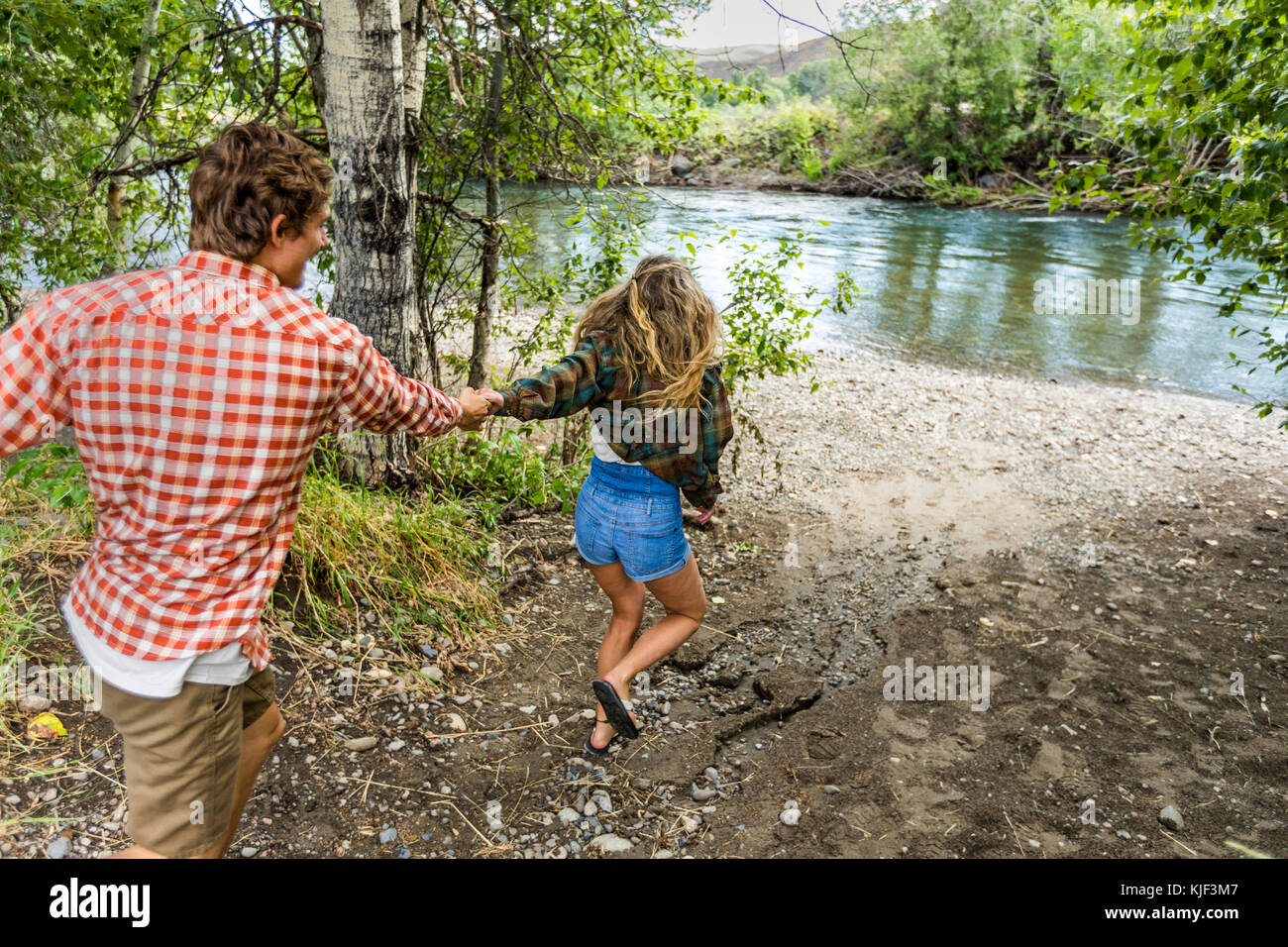Caucasian teenage girl leading boy to river Stock Photo - Alamy