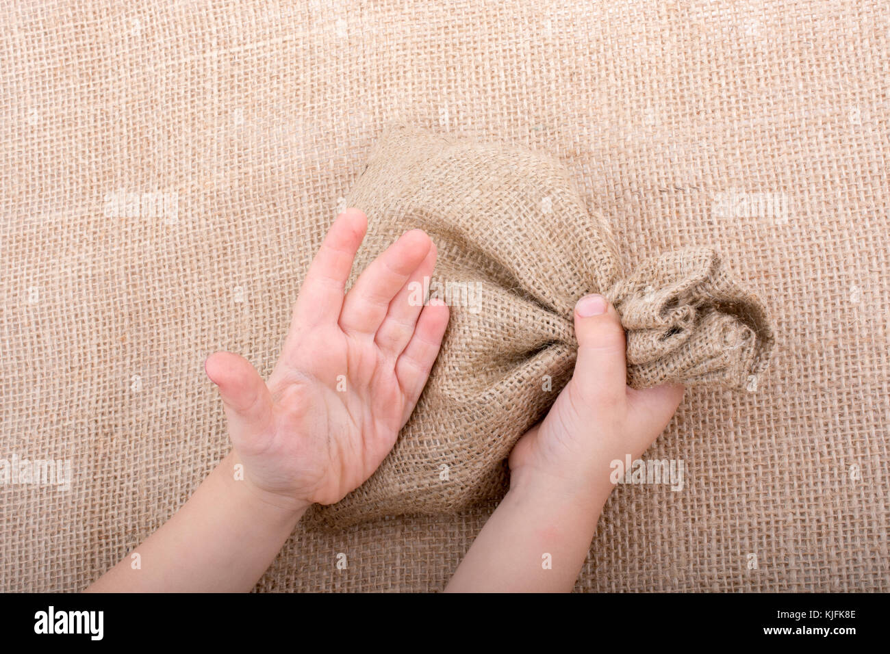Hand holding an empty little sack made of linen Stock Photo - Alamy