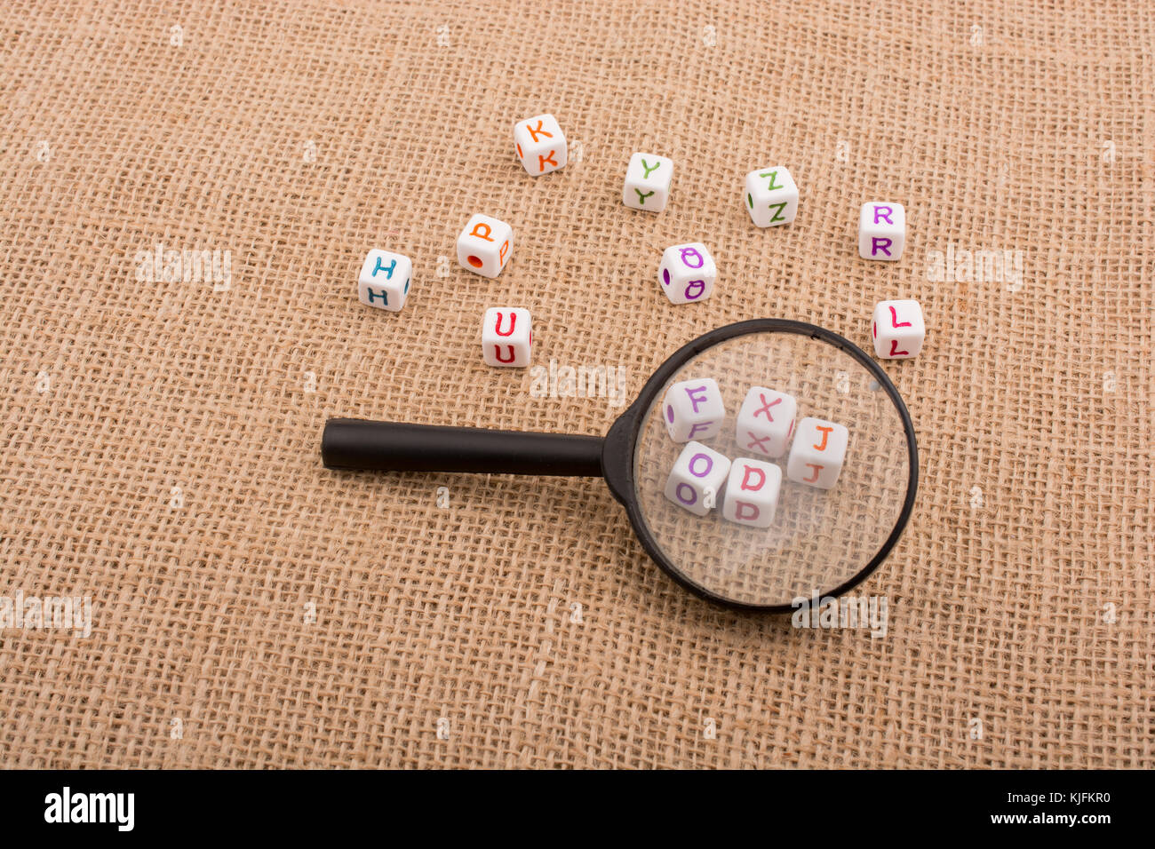 Colorful alphabet letter cubes behind a magnifying glass Stock Photo ...