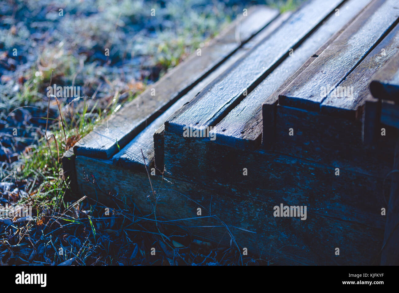 Outdoor wooden steps covered by ice crystals at cold autumn morning ...