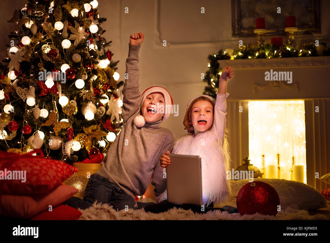 Excited children near Christmas tree Stock Photo - Alamy