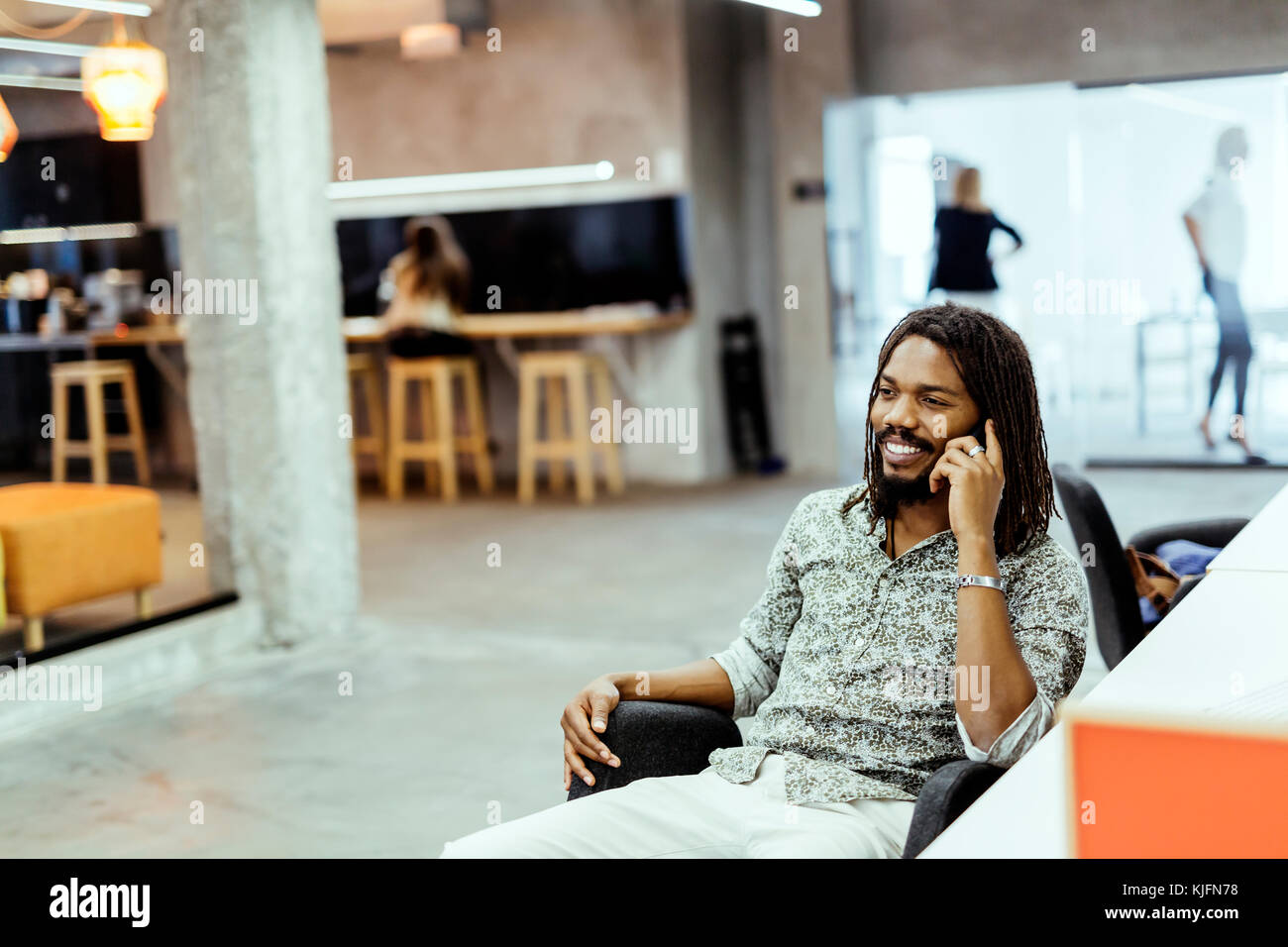 Handsome black man using phone in office Stock Photo - Alamy
