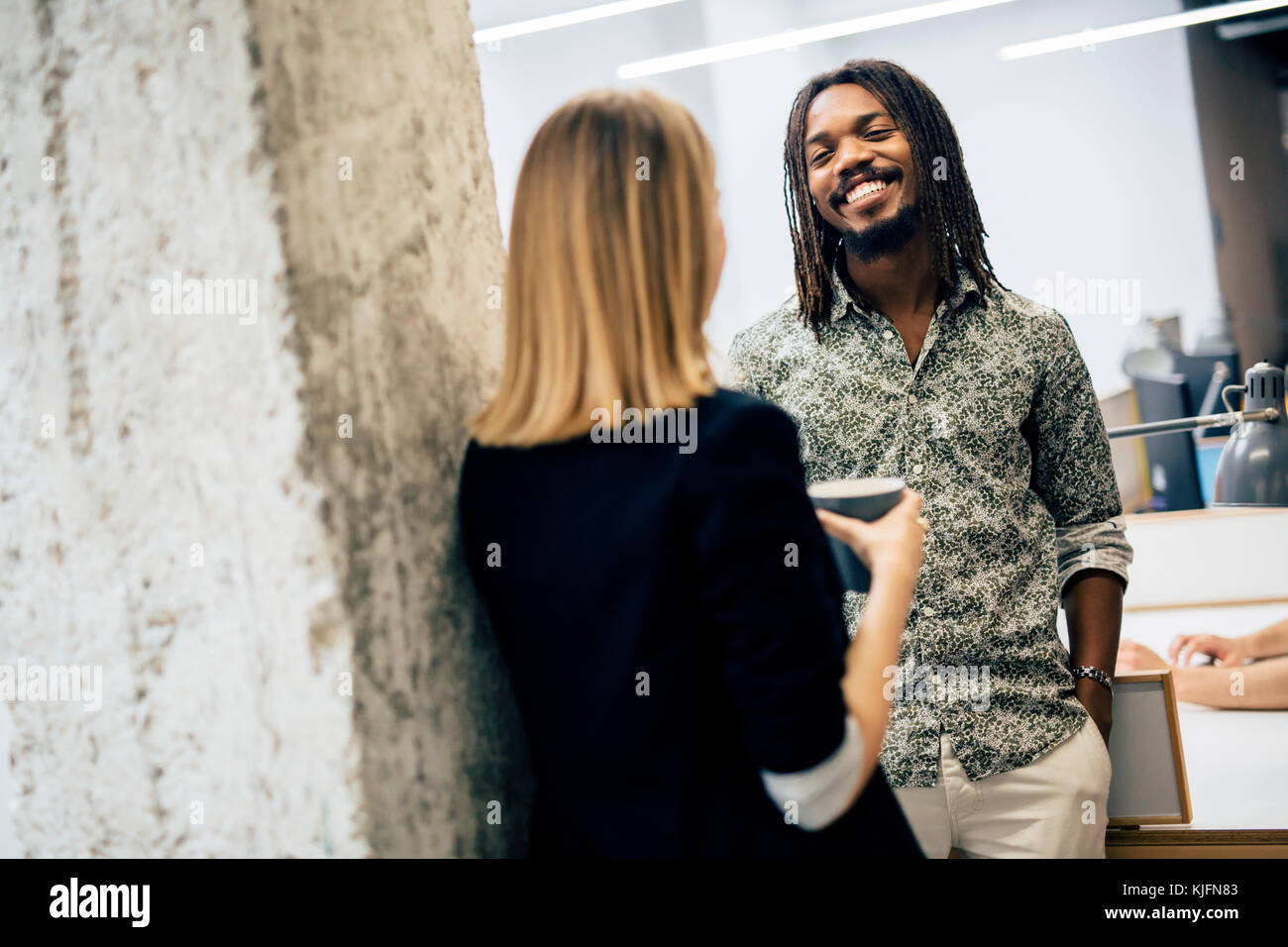 Colleagues in office talking Stock Photo - Alamy