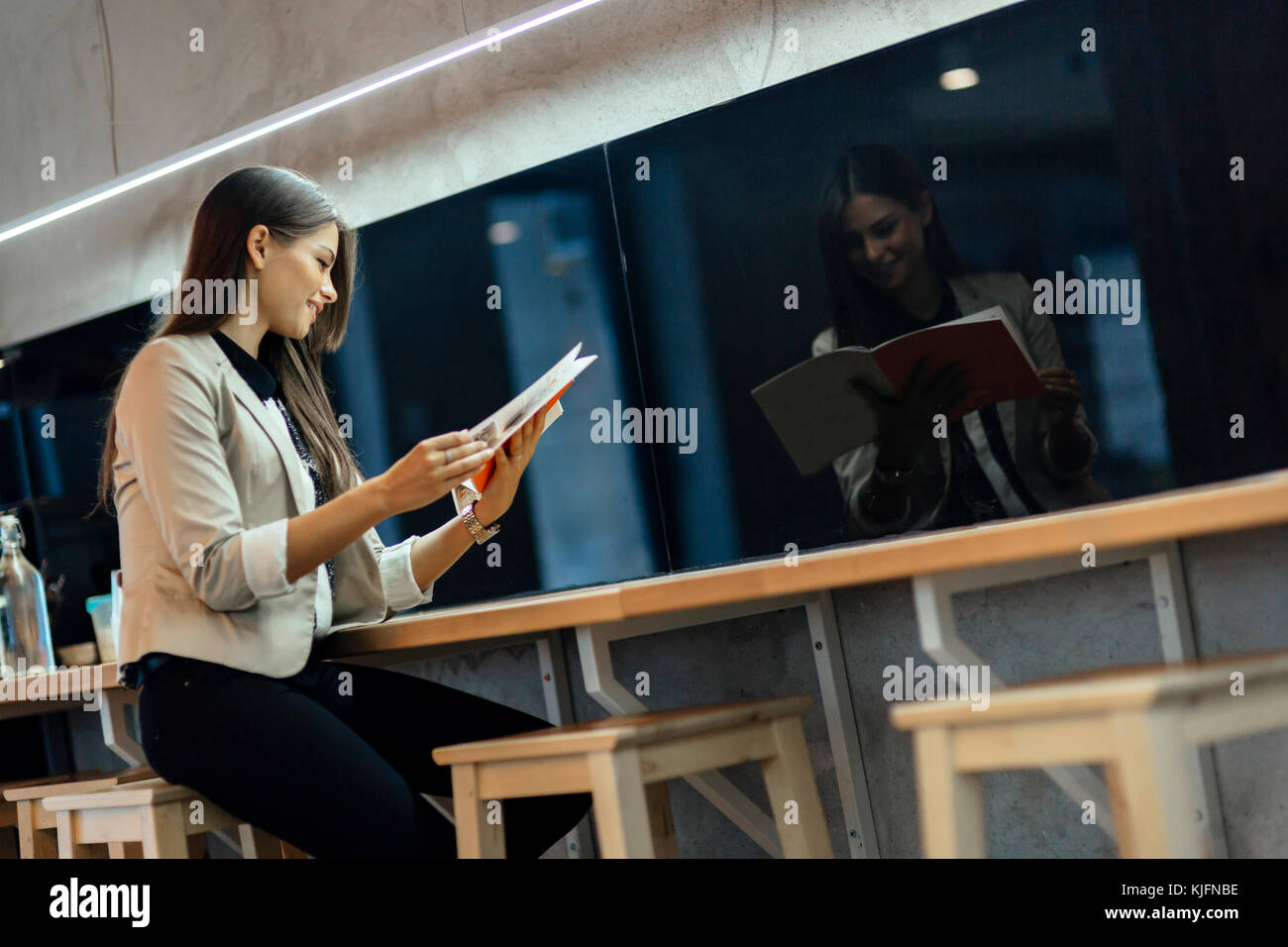 Beautiful woman reading the menu on a counter Stock Photo - Alamy