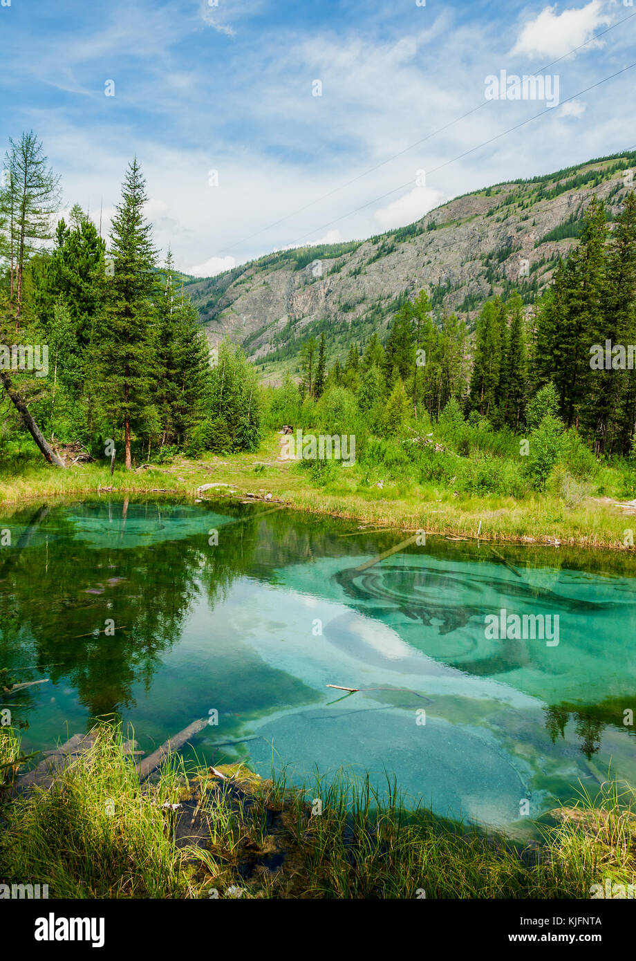 Beautiful forest geyser lake with clear turquoise water on a background ...