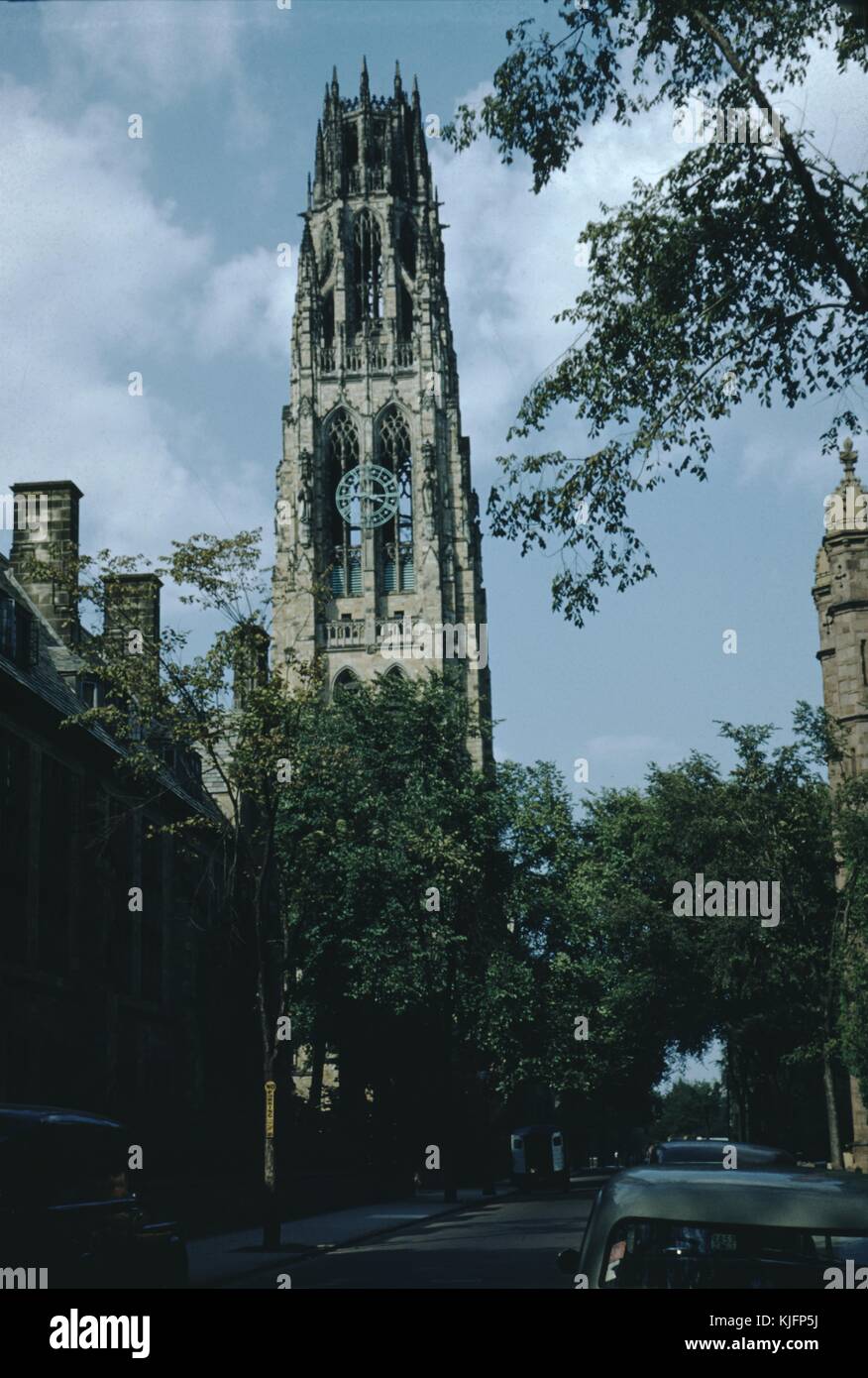 Color photograph with a tall, ornate, stone clock tower in the ...