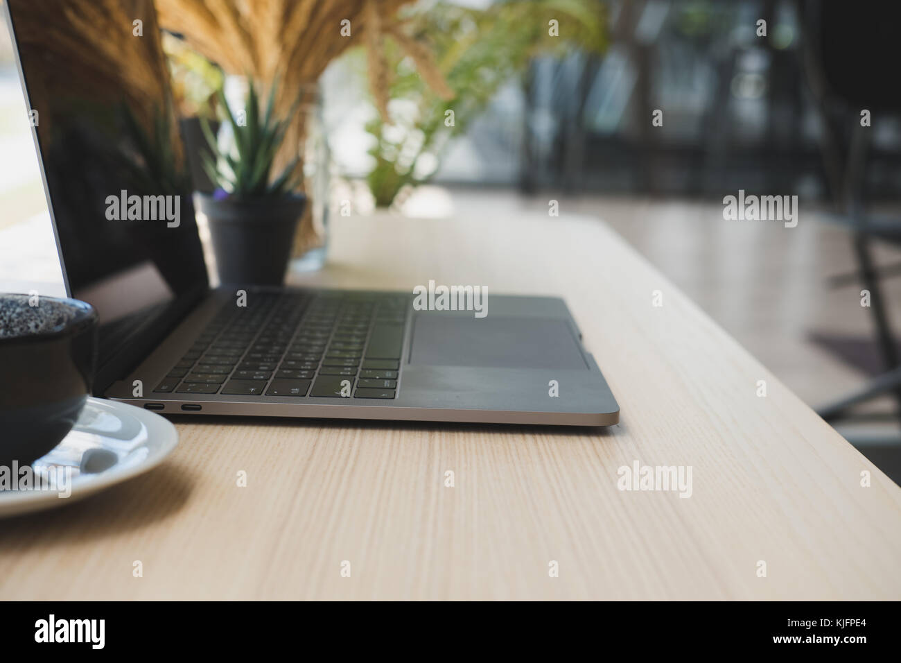 computer notebook, coffee cup on wood desk. laptop at office workplace ...