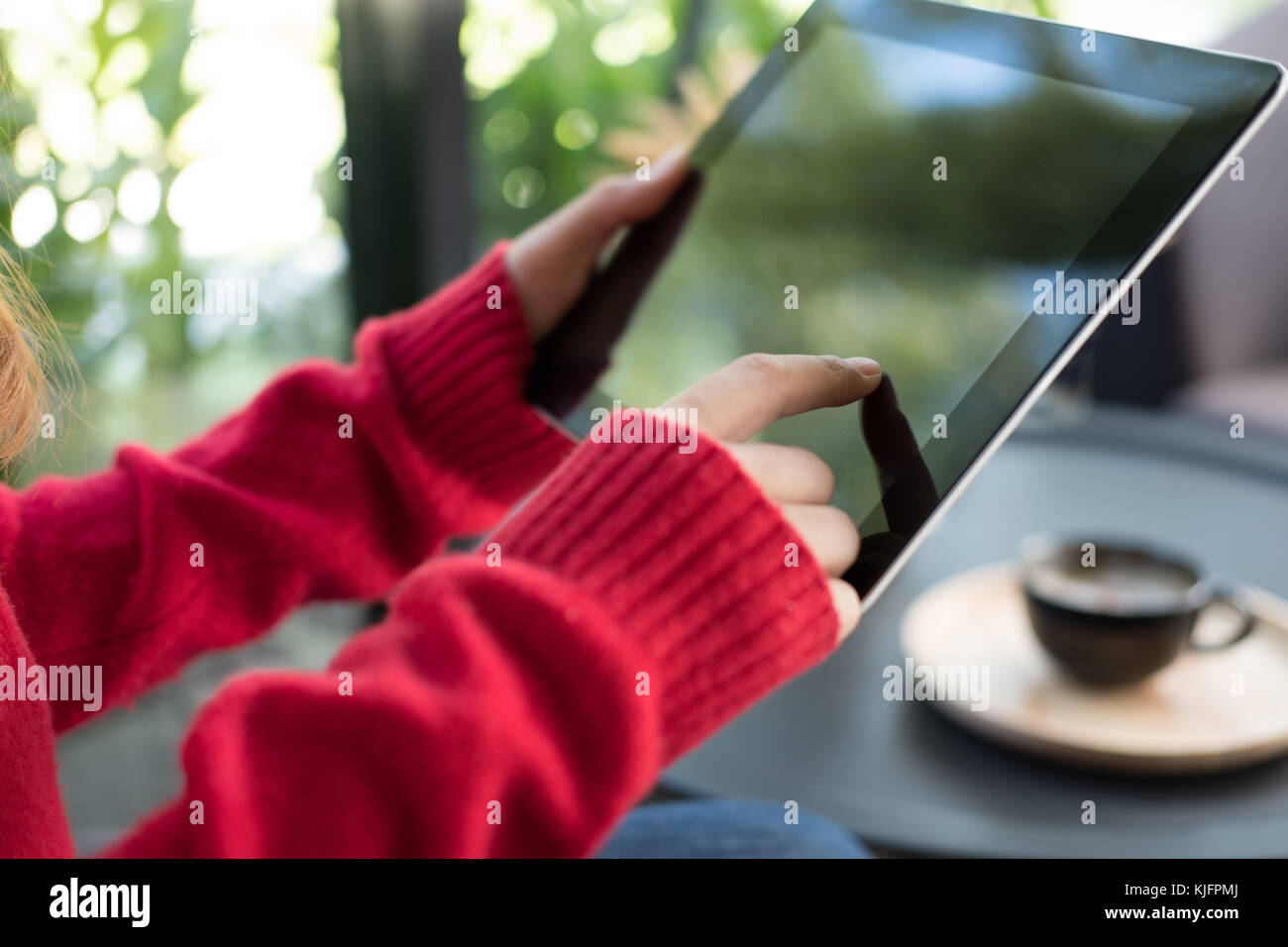 young woman wearing red sweater typing text message on application on ...
