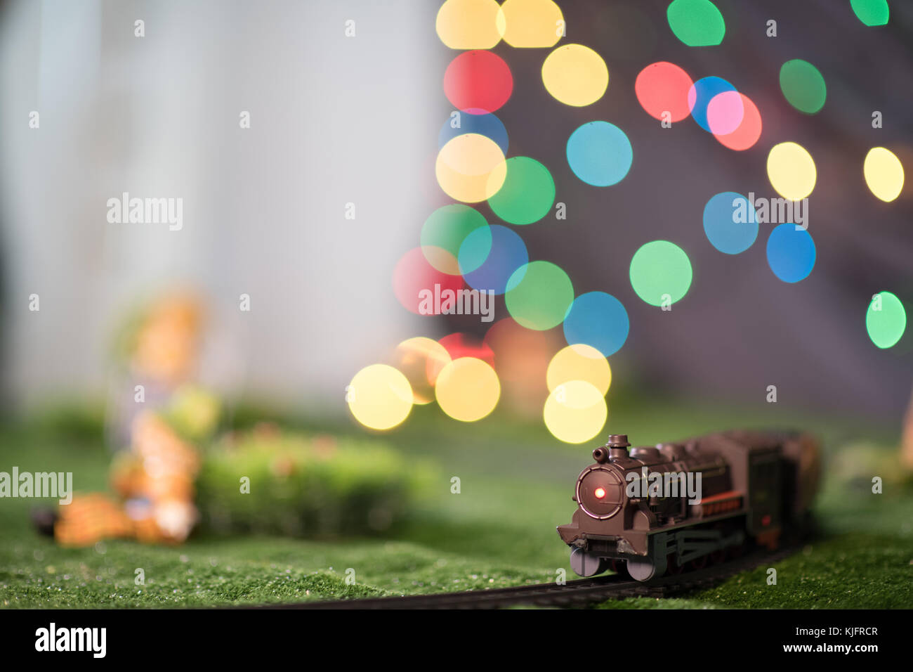 model train on railway with colorful bokeh. Locomotive on track layout ...