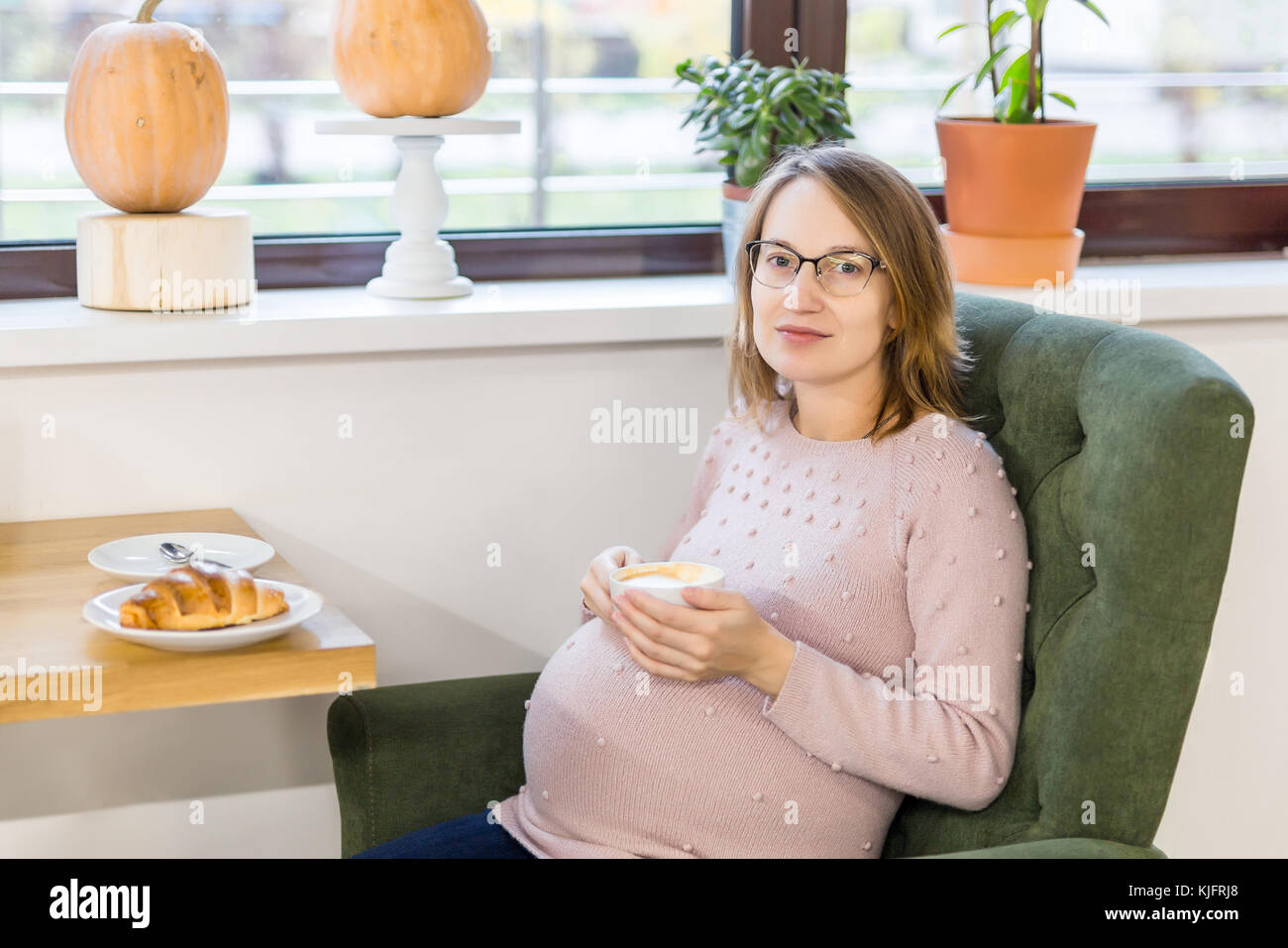 Young Beautiful Caucasian Pregnant Woman In Glasses Sitting In A Cafe
