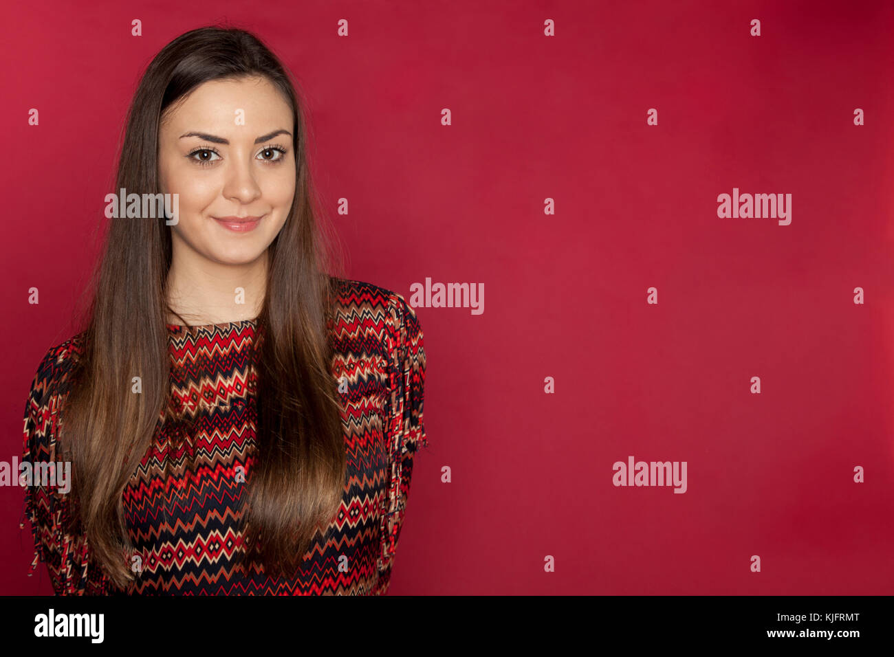 beautiful smiling woman poses on red background, copy space Stock Photo ...
