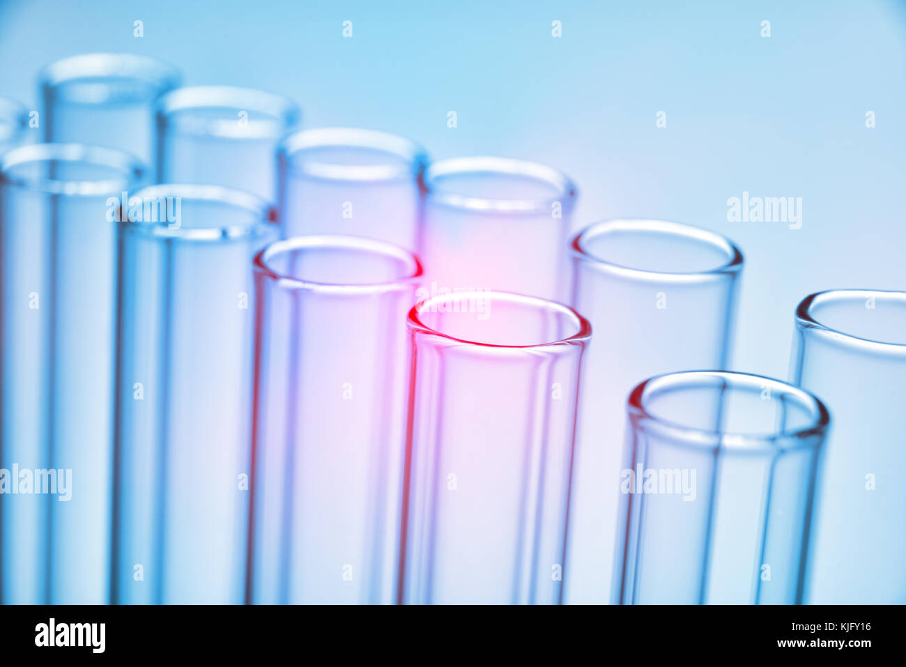 Two rows of empty glass test tubes blue background. Elevated view Stock ...