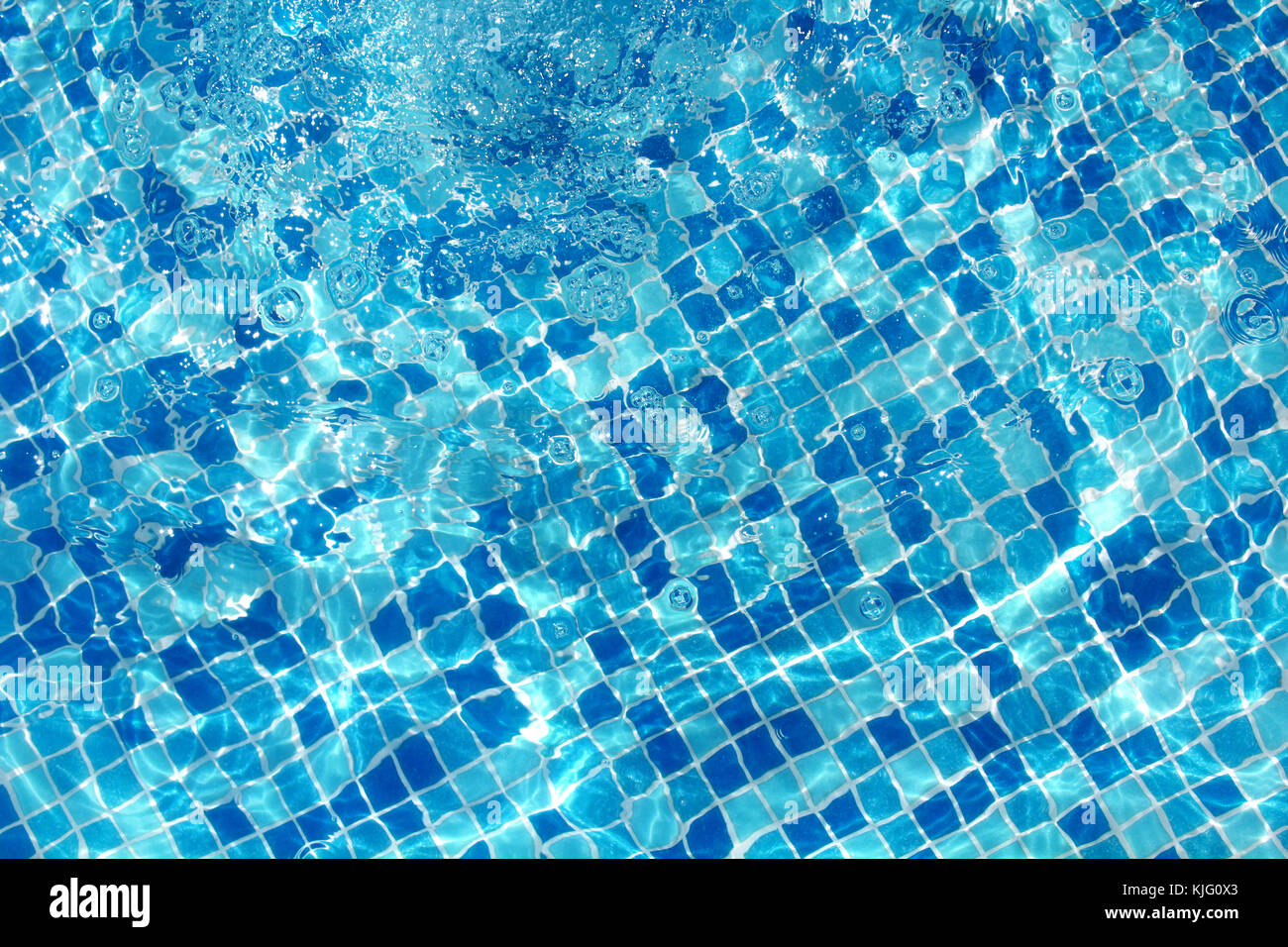 Sun reflection on the blue clear water ripples of swimming pool with ...