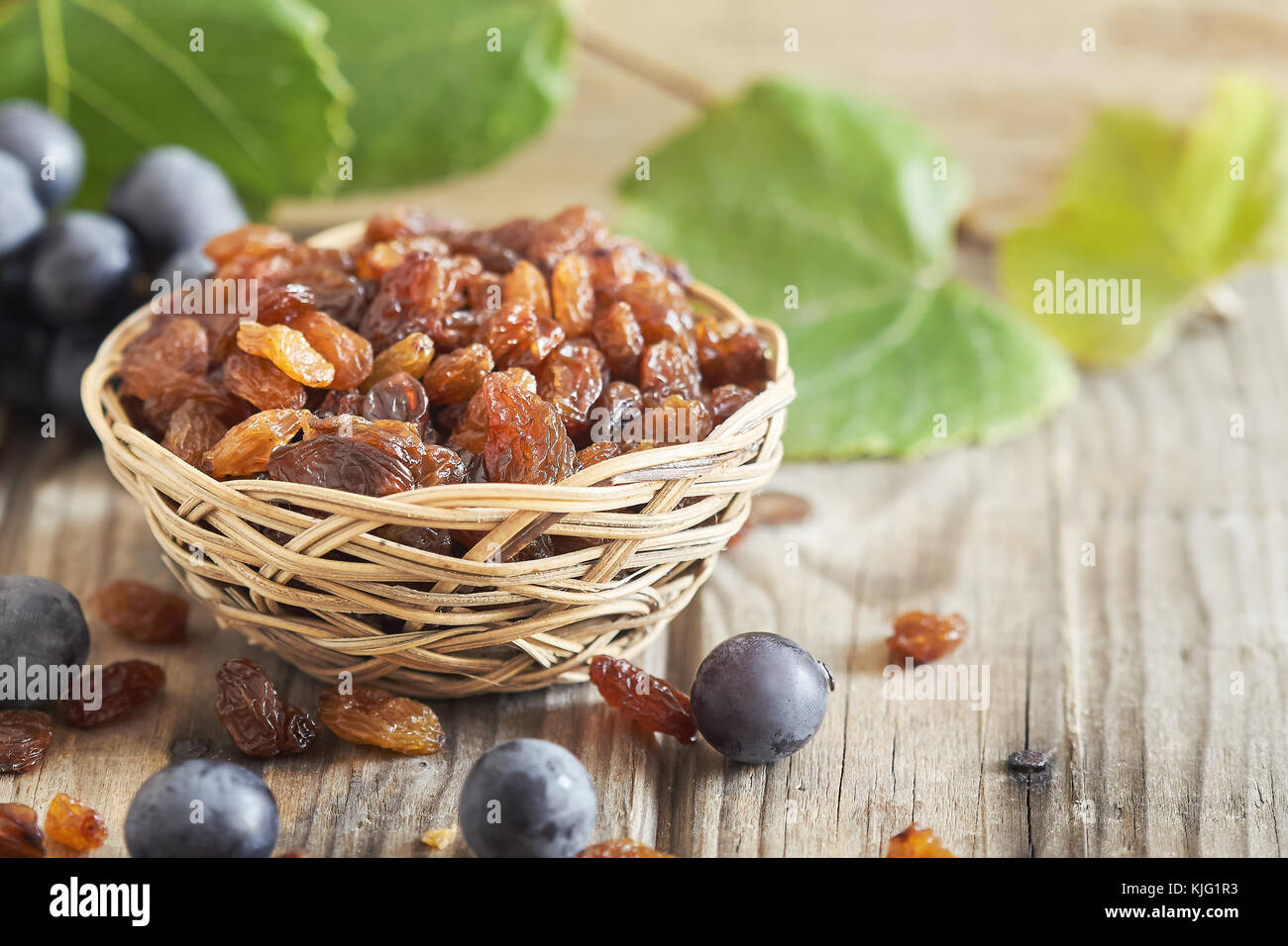 Raw raisins (dried grape) in woven basket. Copy space Stock Photo - Alamy
