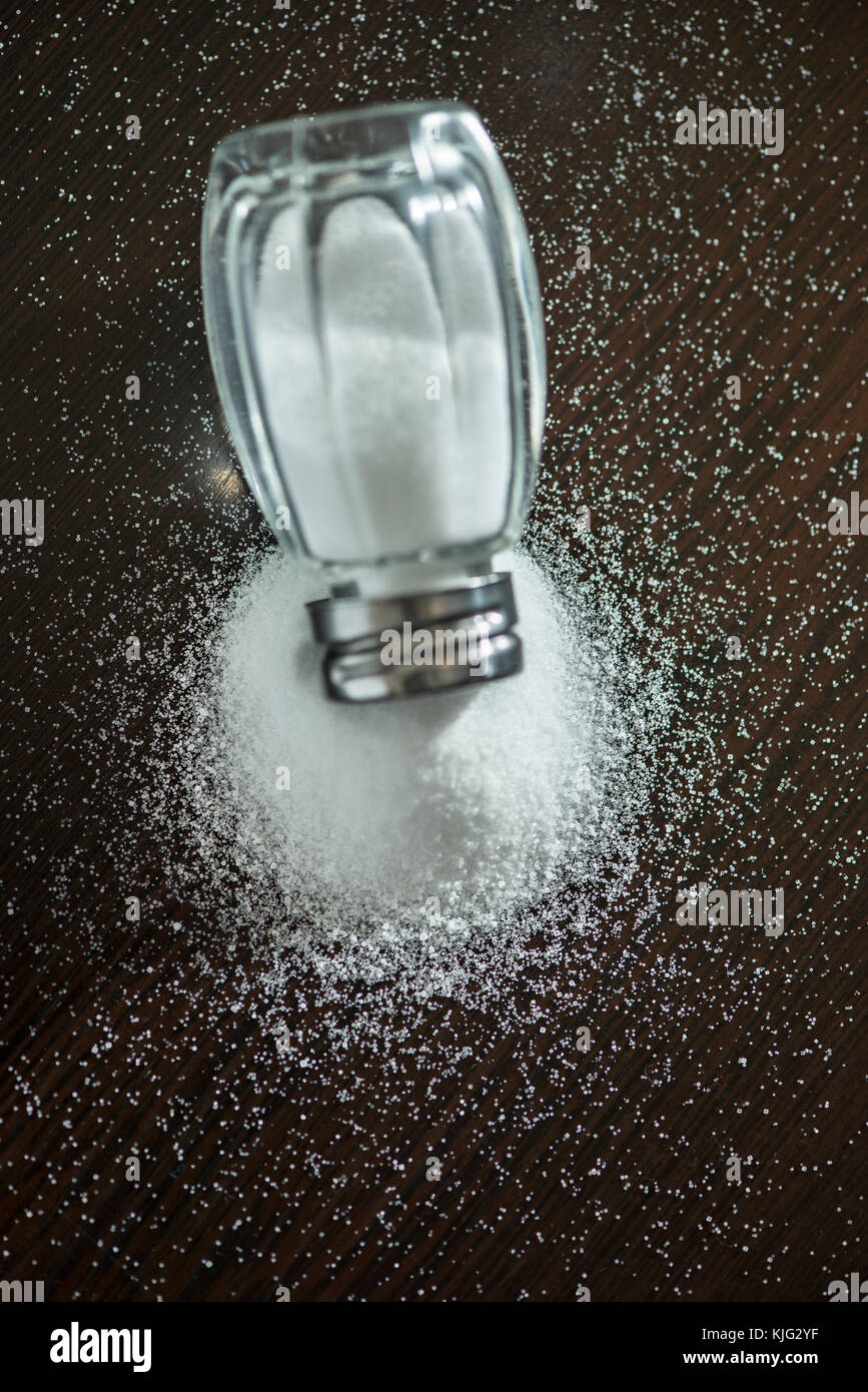 Salt shaker on pile of salt. Dark background Stock Photo - Alamy