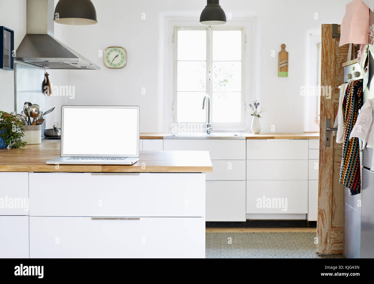 Laptop standing on worktop in a modern kitchen Stock Photo - Alamy