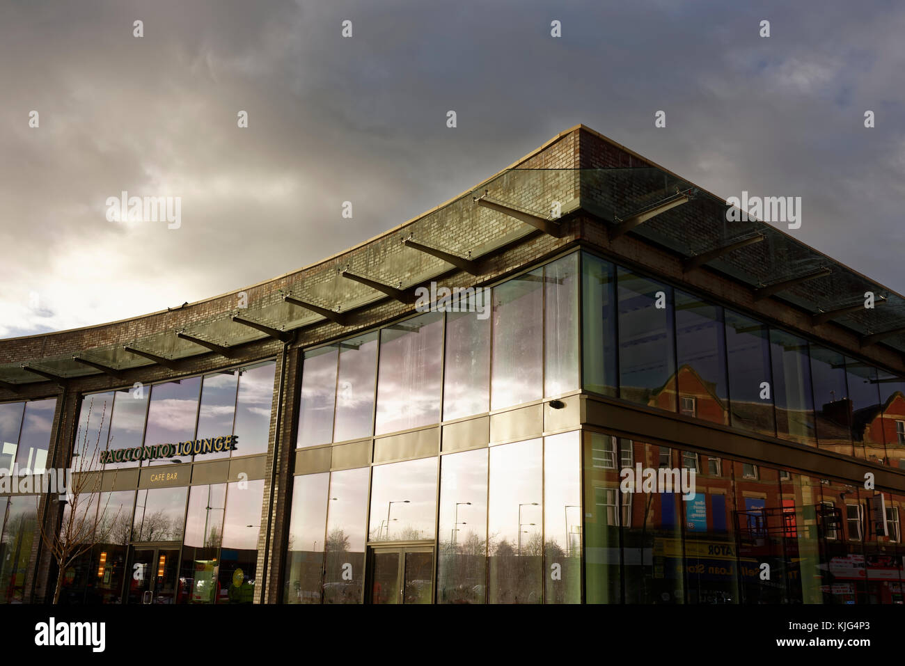 Glass canopy suspended on stainless steel brackets over curtain wall on ...