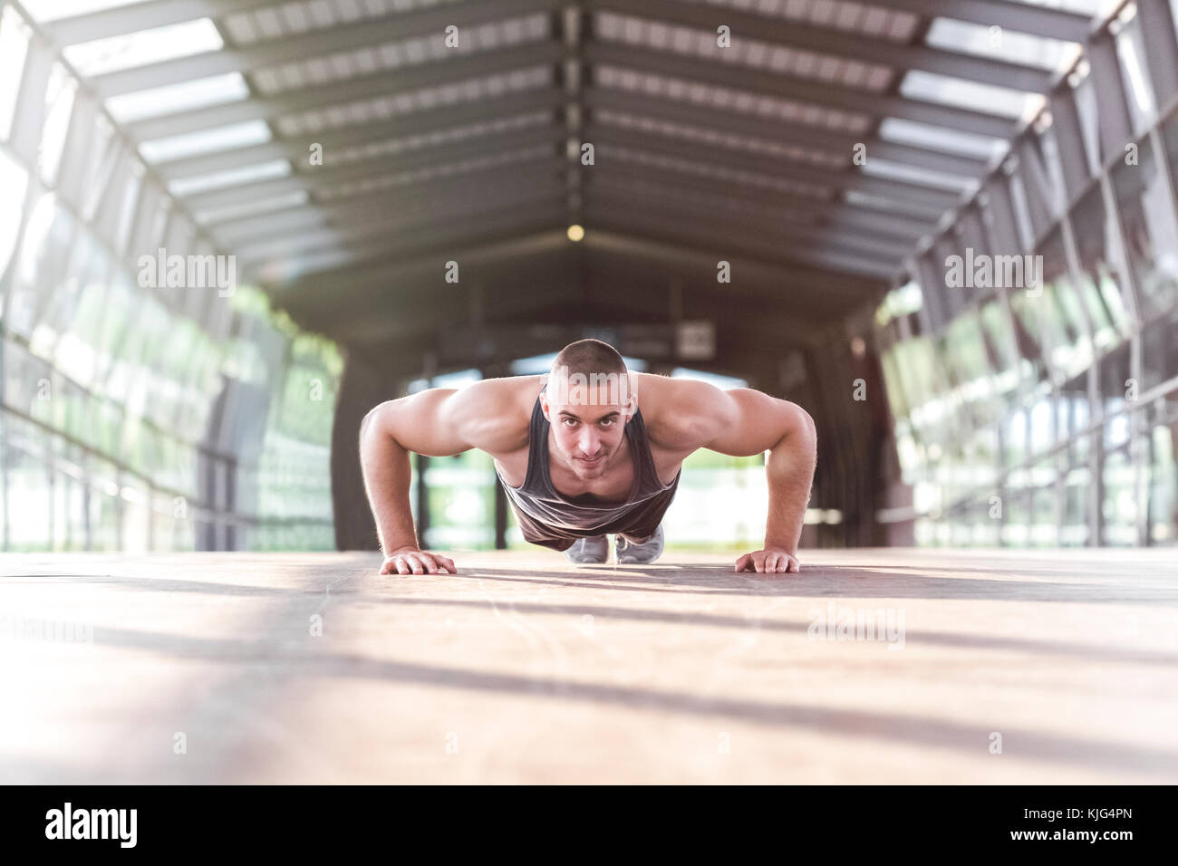 Young man doing push-ups on a bridge Stock Photo - Alamy