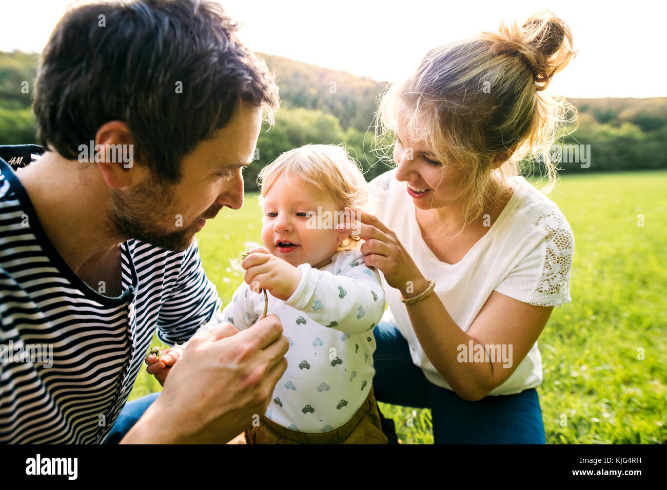 Cute little boy with parents on meadow Stock Photo - Alamy