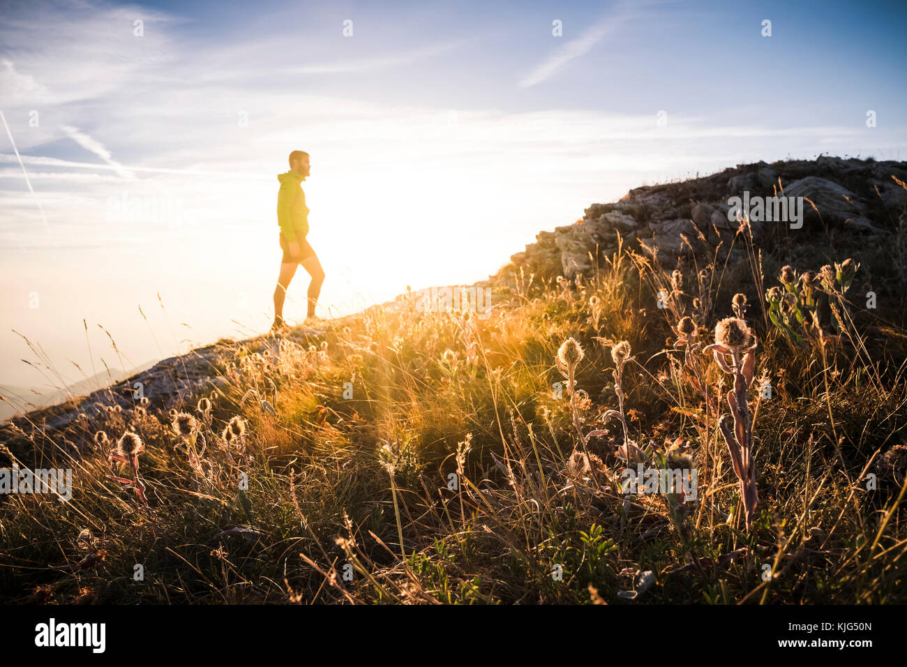 Italy, mountain running man standing on trail Stock Photo - Alamy