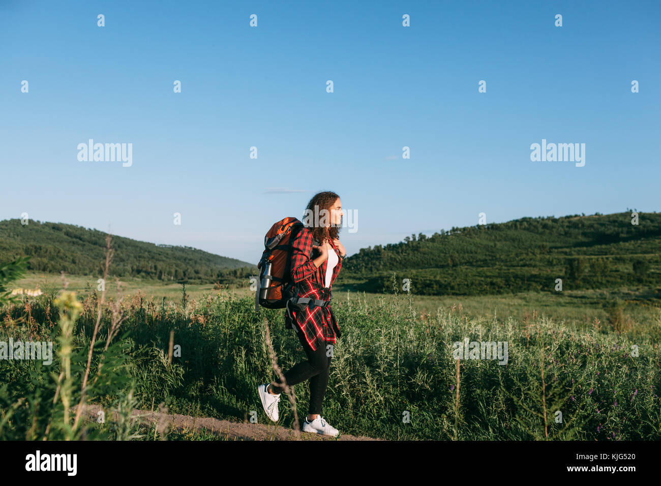 Teenage girl with backpack hiking in nature Stock Photo - Alamy
