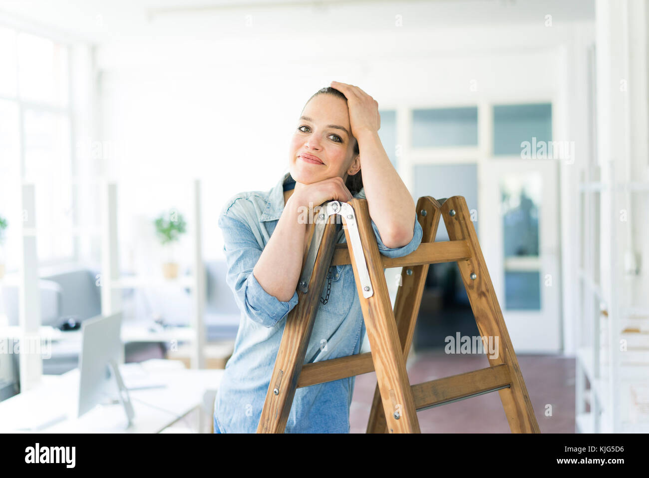 Portrait of smiling woman leaning on ladder Stock Photo - Alamy