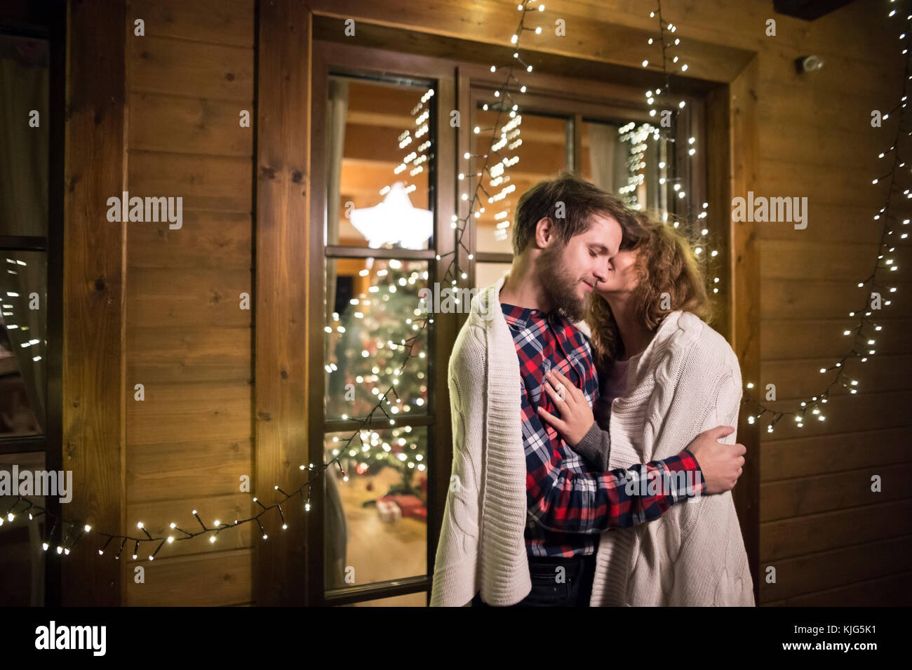 Young couple wrapped in a blanket cuddling outdoors at night Stock ...