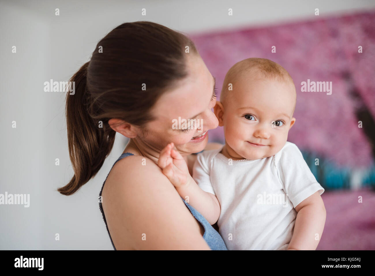 Mother holding baby girl at home Stock Photo - Alamy